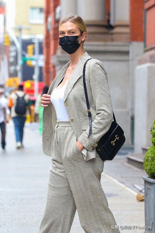 Supermodel Karlie Kloss wearing a suit with a Gucci bag on his shoulder ...
