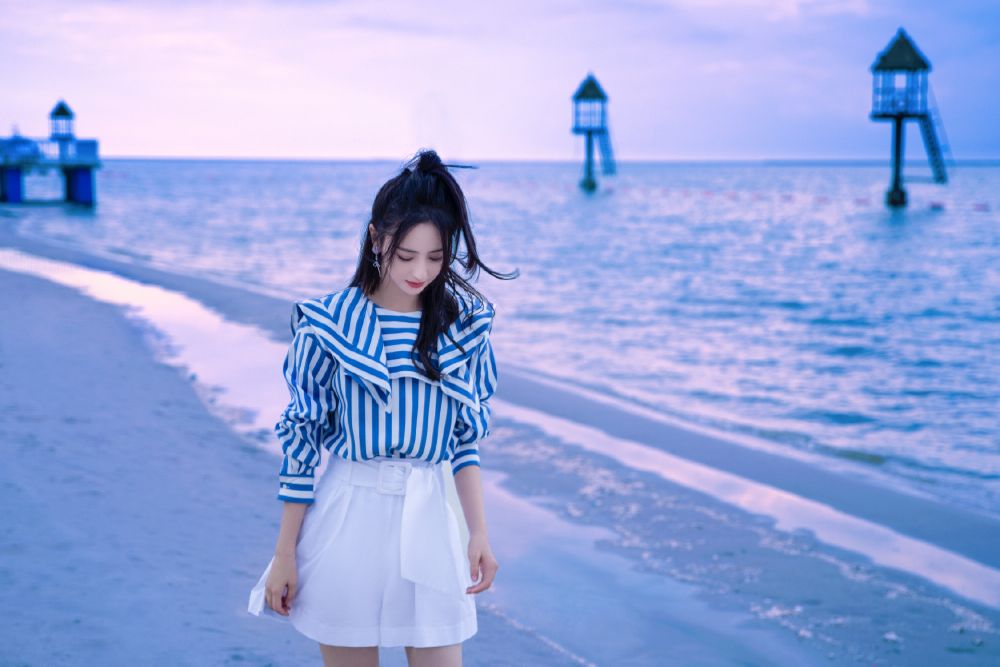 Tong Liya walks along the beach, fresh and elegant, with a sweet smile ...