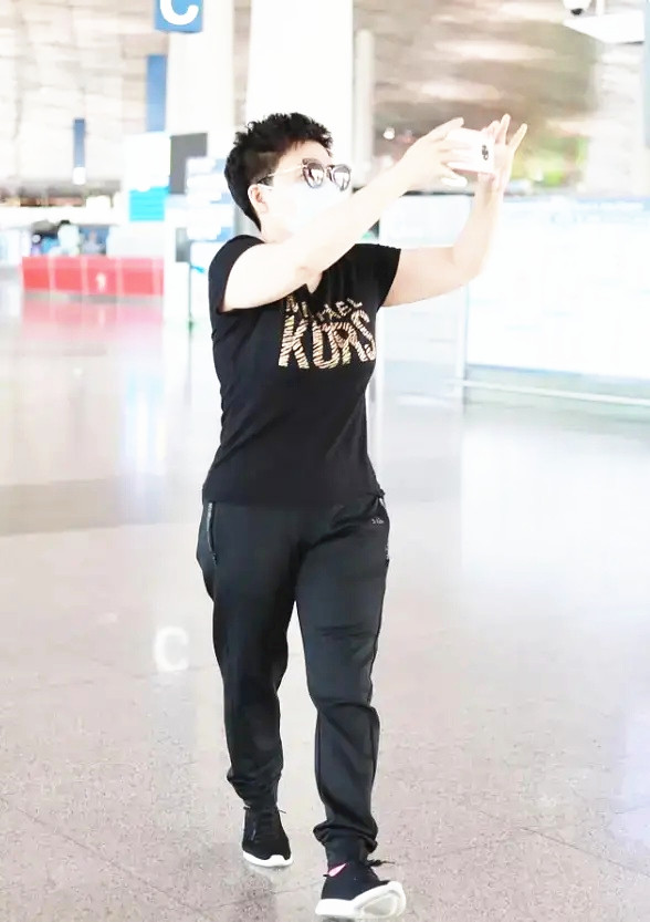 "Ping Pong Queen" Deng Yaping walks around the airport, wearing black ...